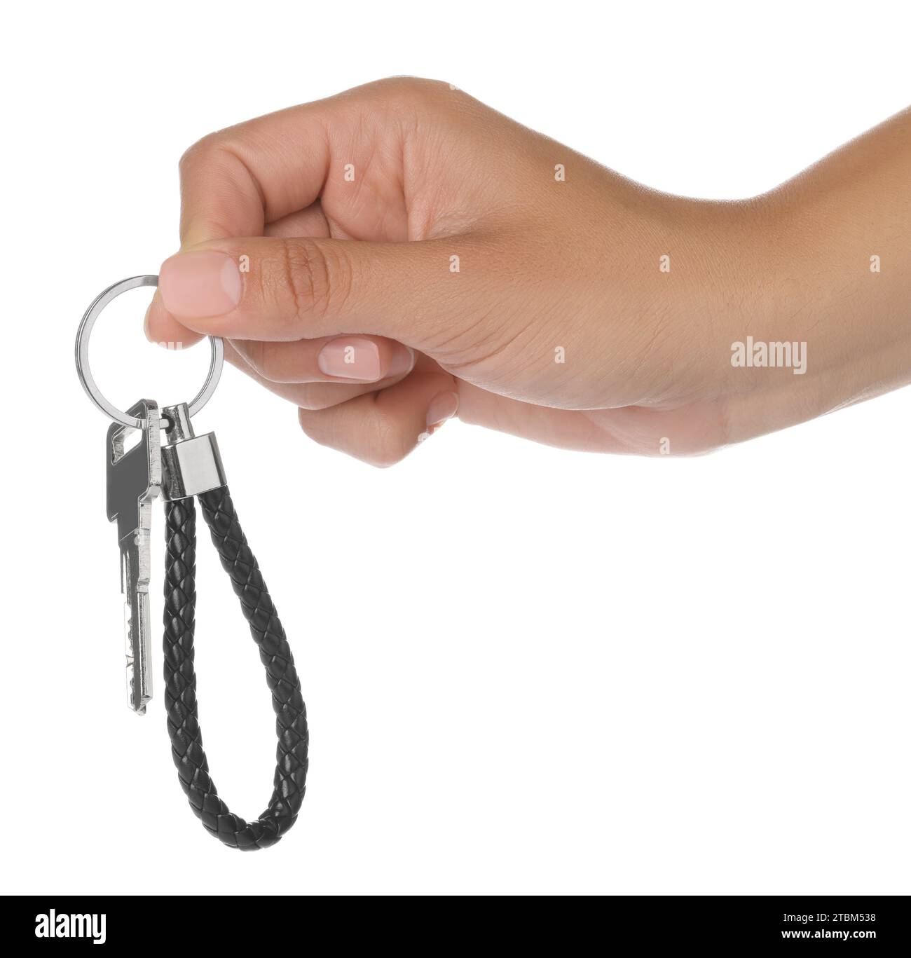 Woman holding key with black leather keychain on white background ...