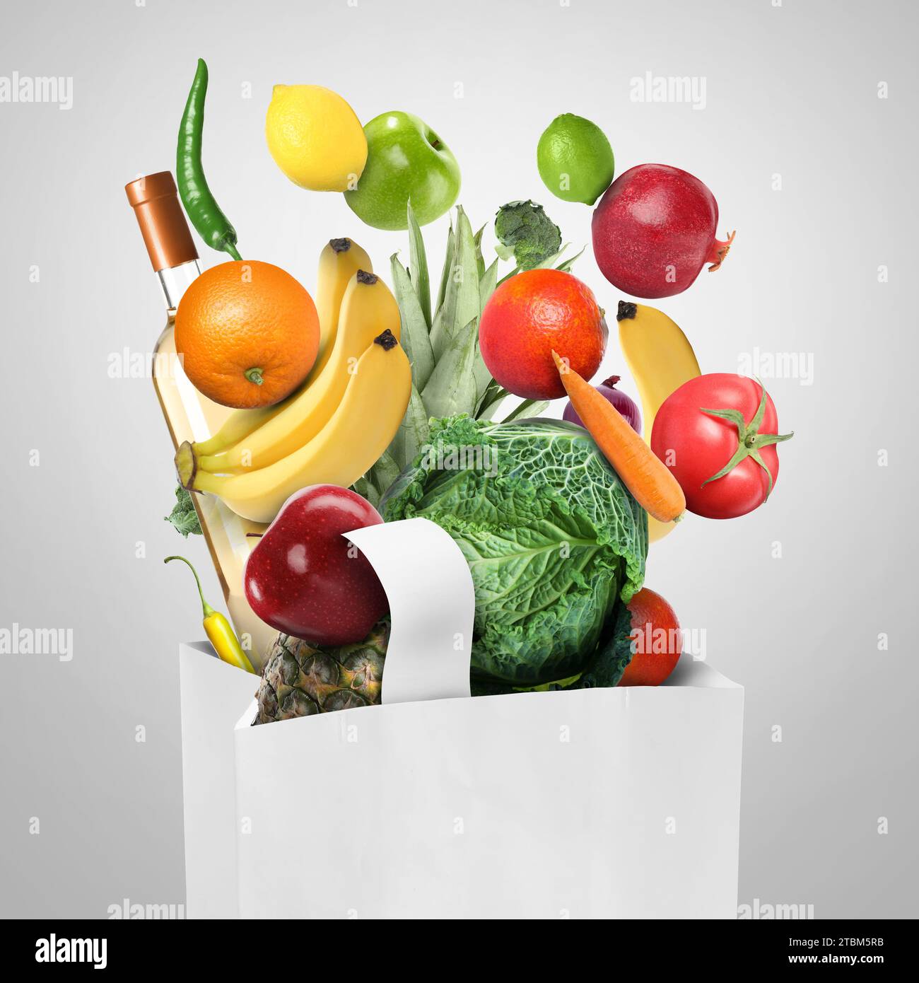 Different food products falling into paper bag on light grey background ...