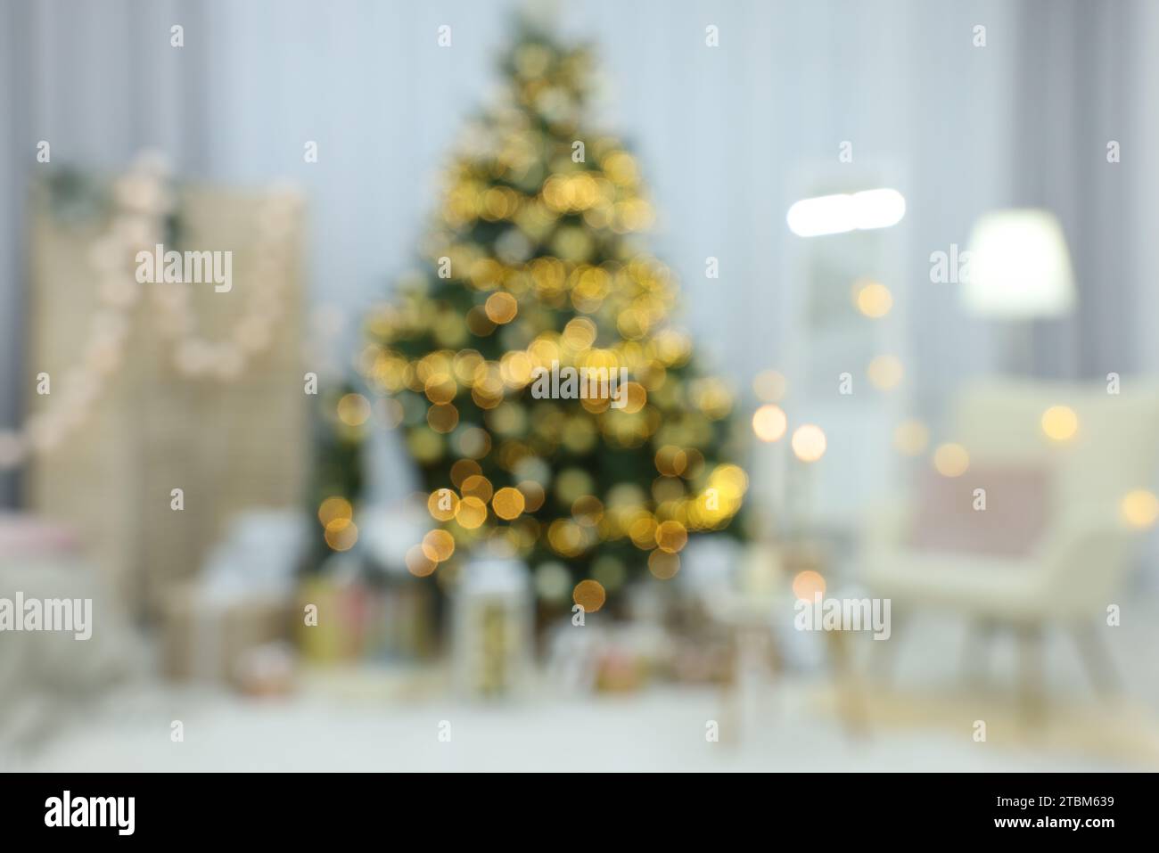 Blurred view of Christmas tree and festive decor in room. Interior ...