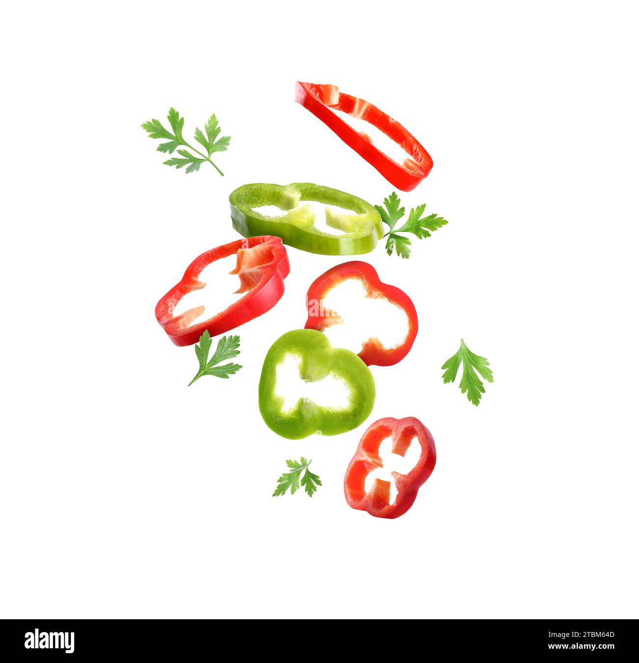 Fresh parsley and slices of bell pepper flying on white background ...