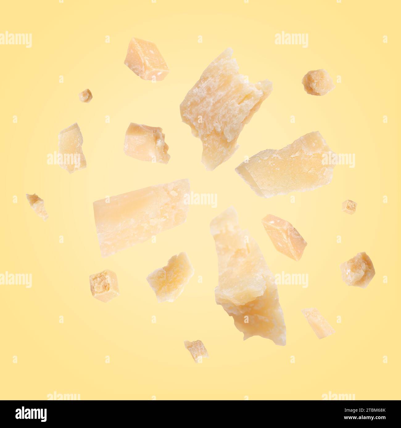 Parmesan cheese in air on pale yellow background Stock Photo - Alamy