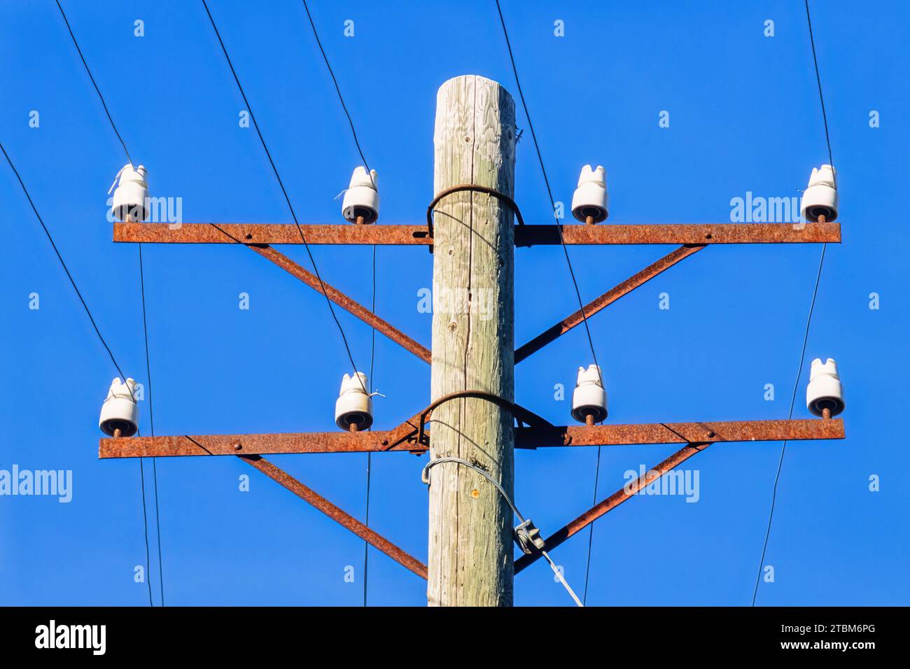 Old telephone pole with telephone wires and white porcelain insulators ...