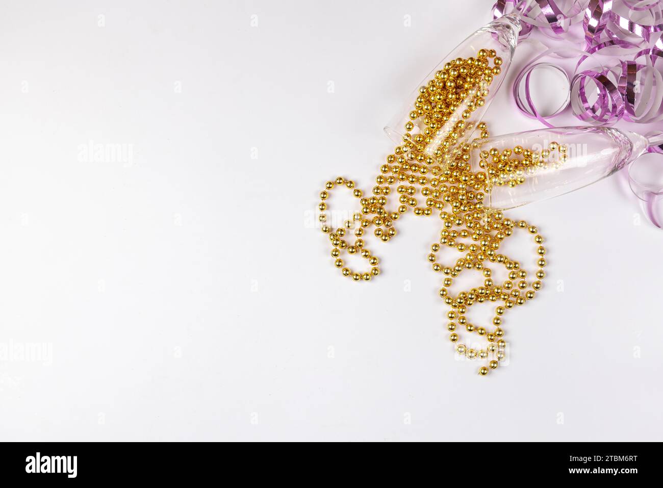 Champagne glasses with gold ball chains, streamers, New Year's Eve ...