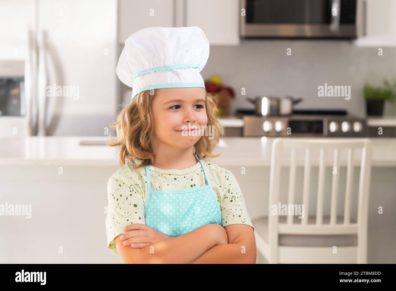 Portrait of funny child chef in kitchen. Chef kid boy baking on the ...