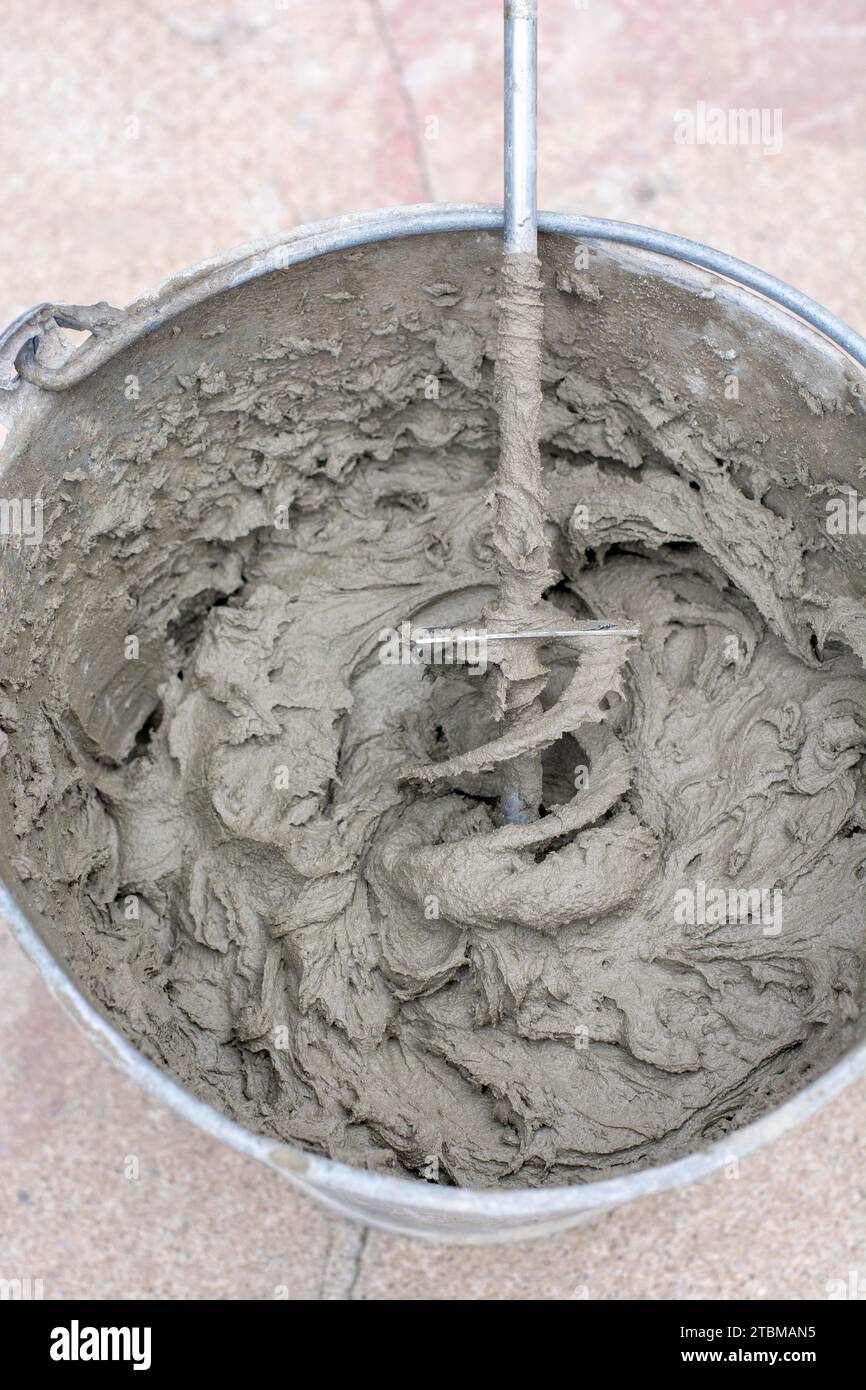 Mixing a plaster solution by an electric drill. Adhesive mixing. Home ...