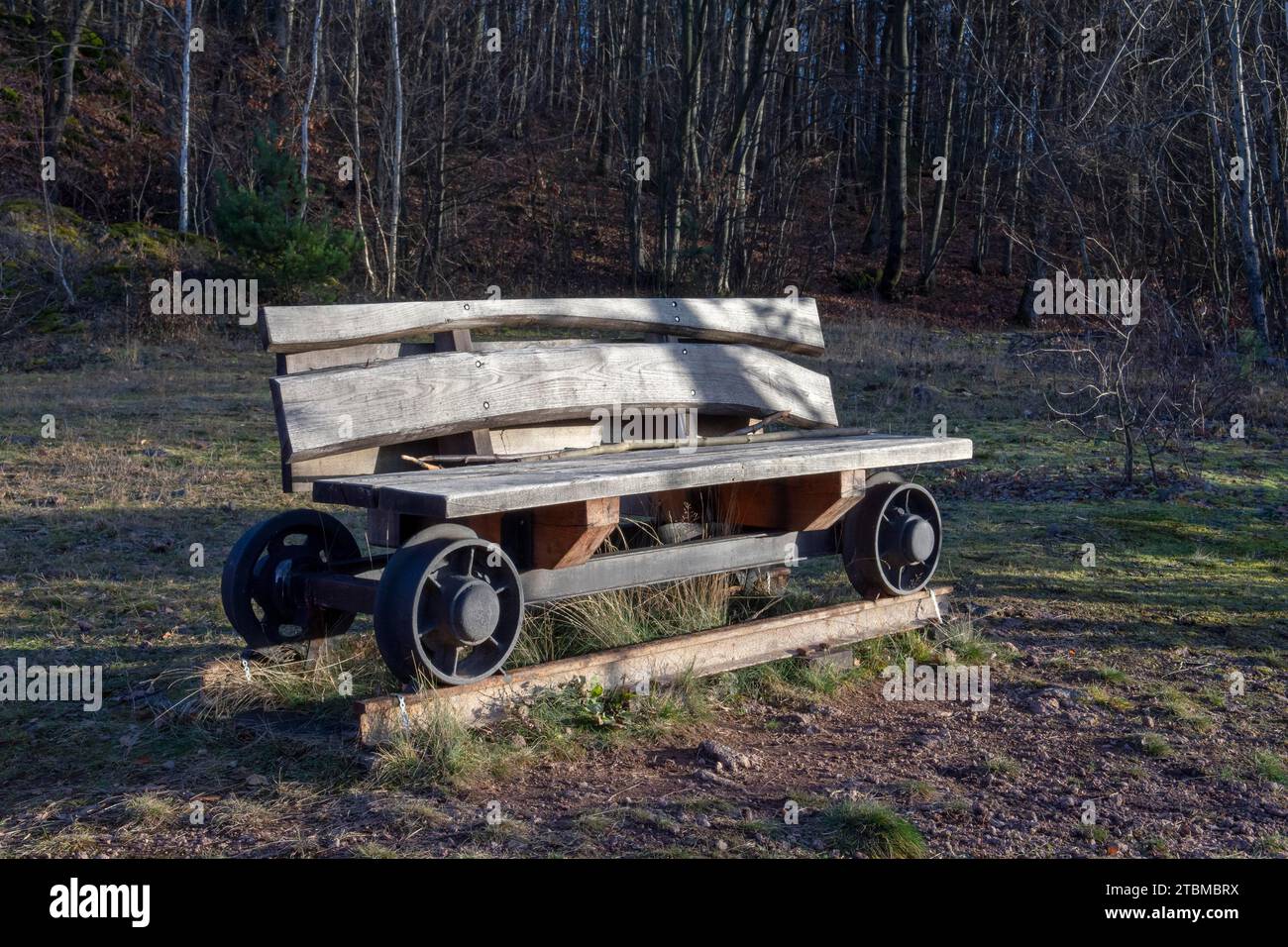 Wooden bench on the wheels from an old mining cart on a rail track ...