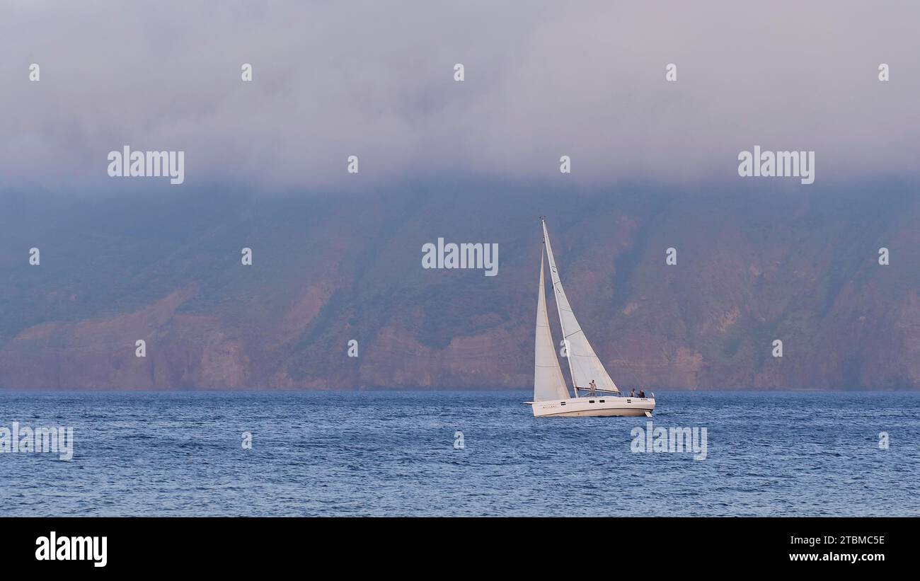 Single sailing boat, lying diagonally in the water, lusts of Lipari ...