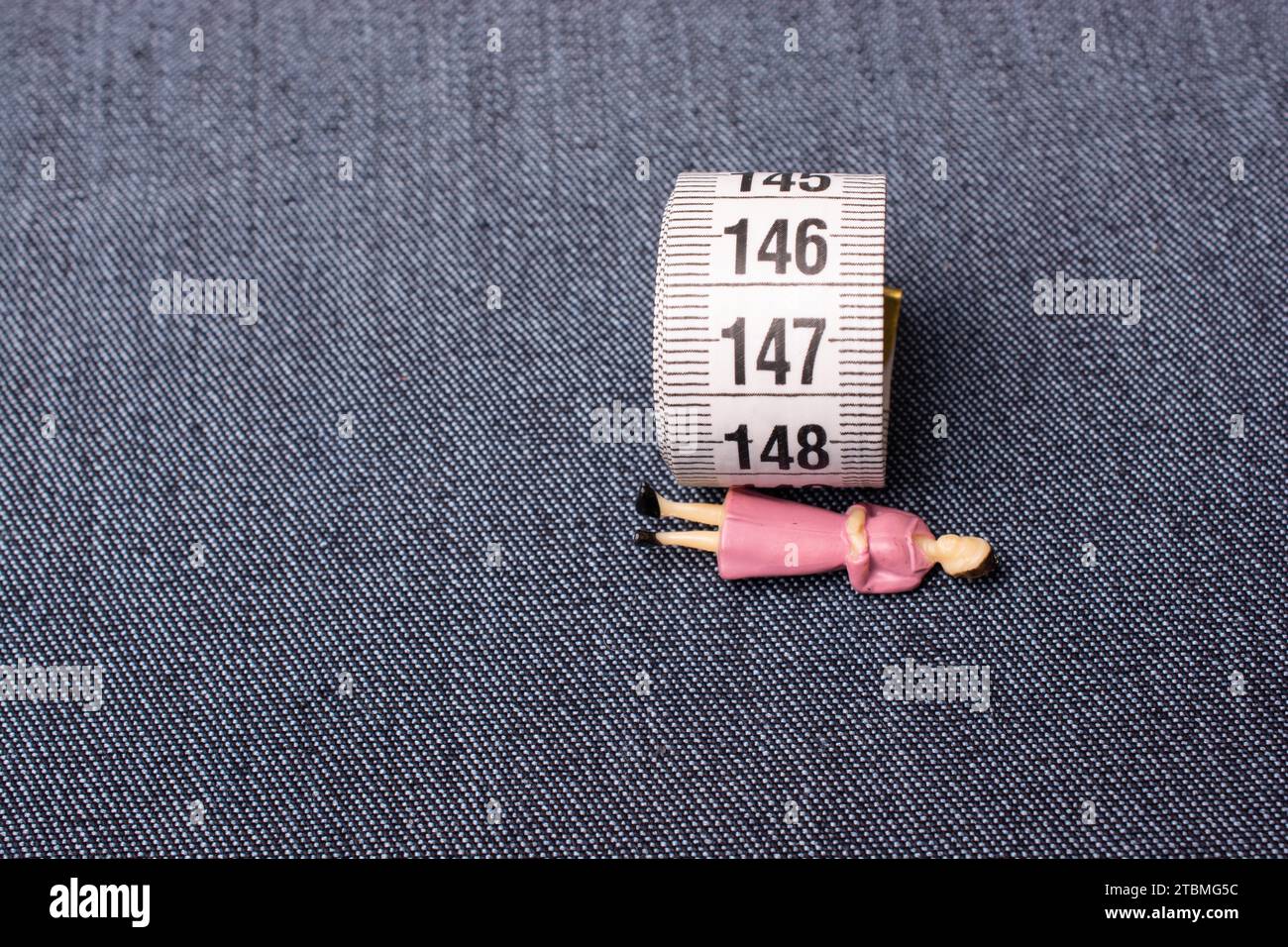 Woman figurine and soft measuring tape. tape measure with metric scale ...