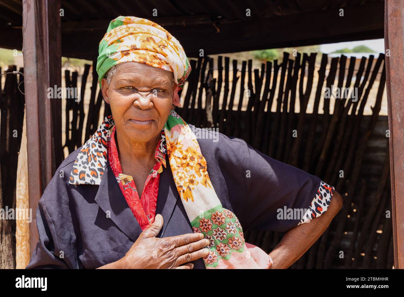 village poor african old woman, wearing a scarf, standing in front of ...