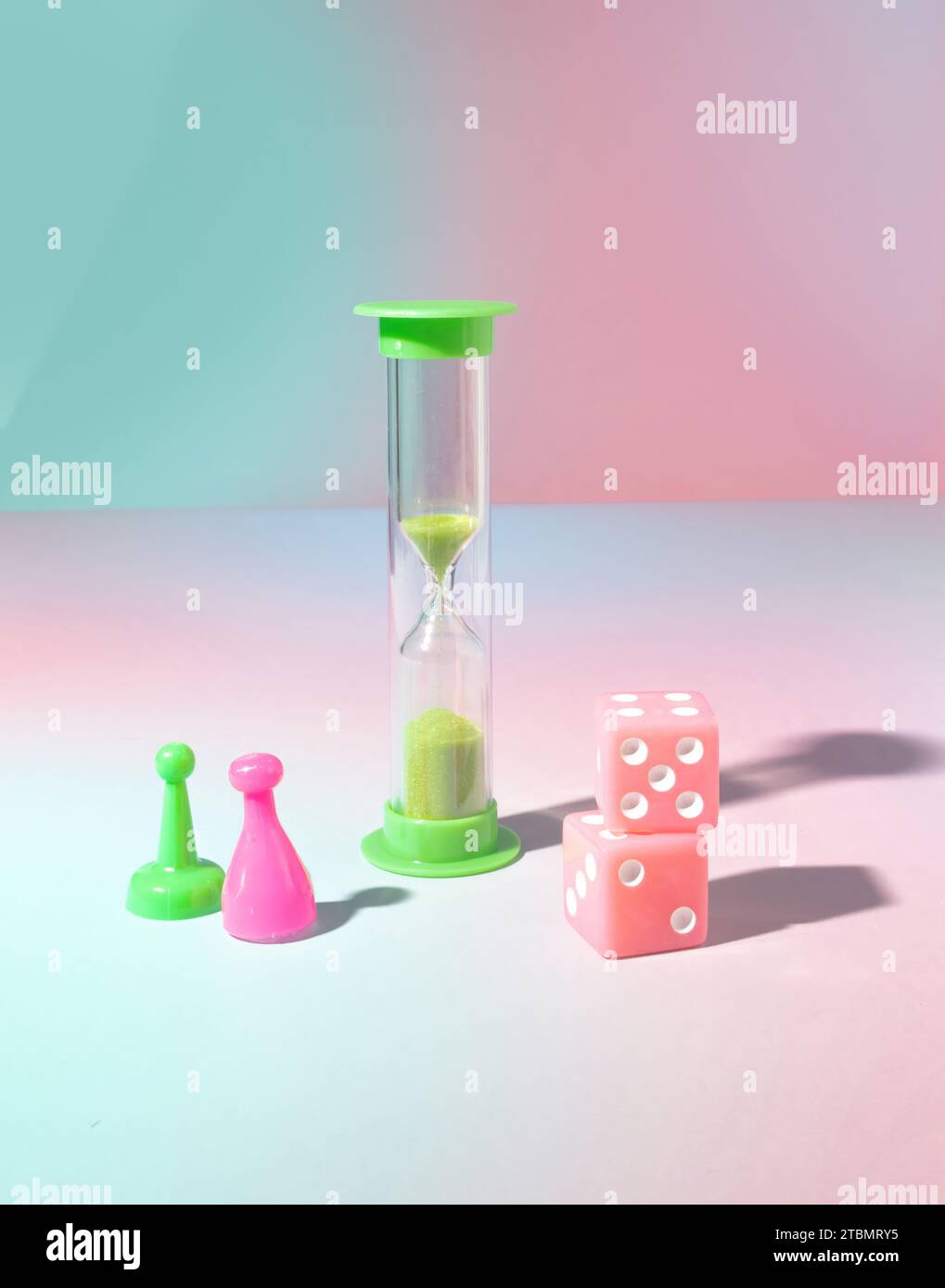 Green Sand Timer, Board Games Pawns, and Pink Dice on a Pastel Blue and ...