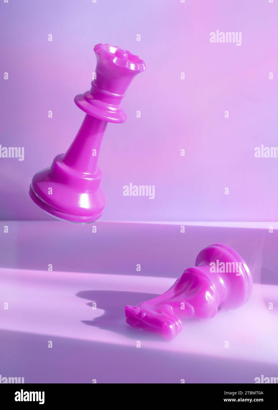 Pink Queen Chess Piece Floating Over Lying Down Knight Chess Piece in ...