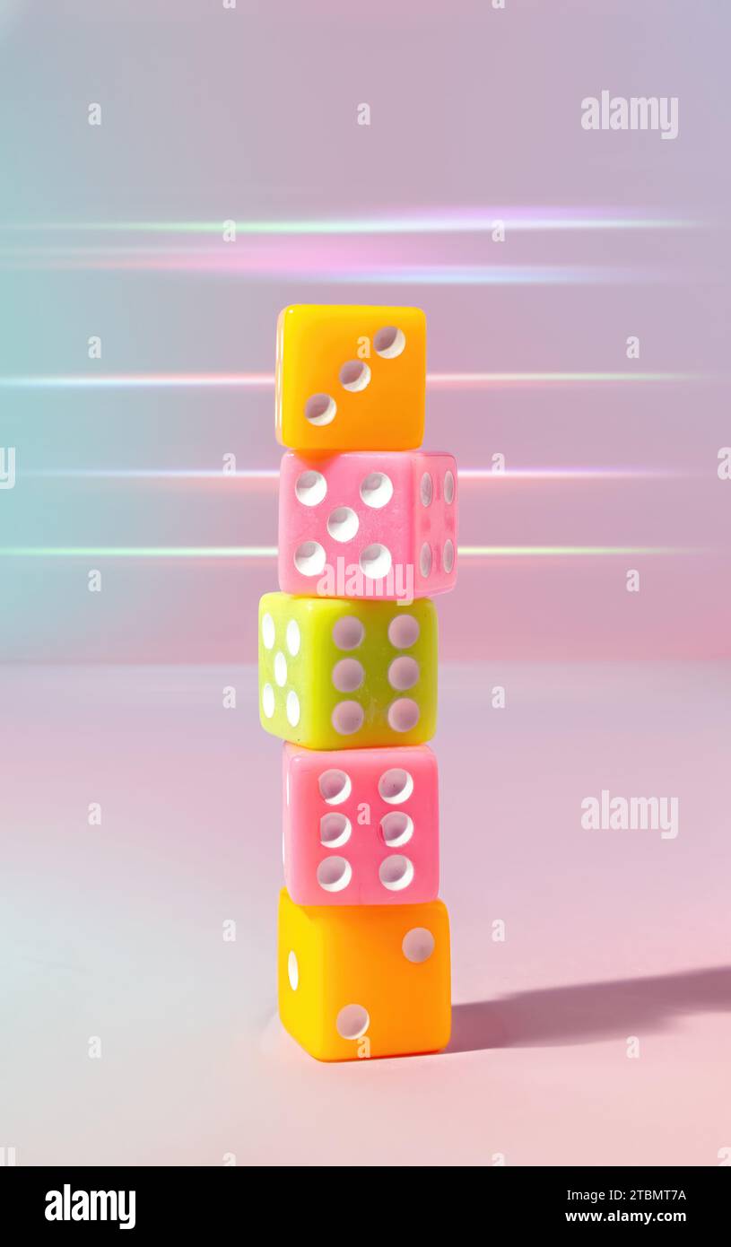 Four Stacked Pastel Colored Dice on a Neon Lit Background in Pastel ...