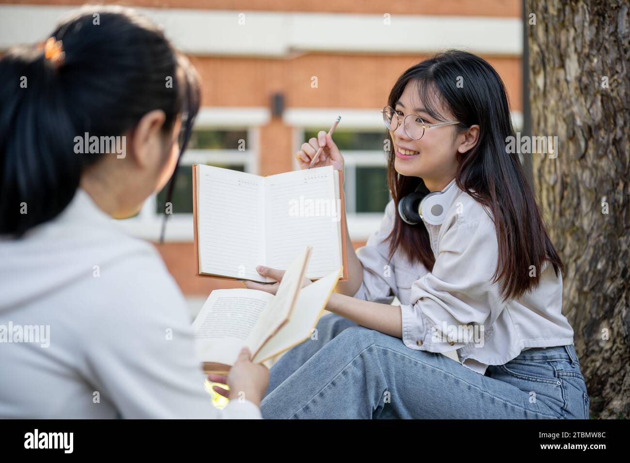 A friendly and positive young Asian female college student is helping ...