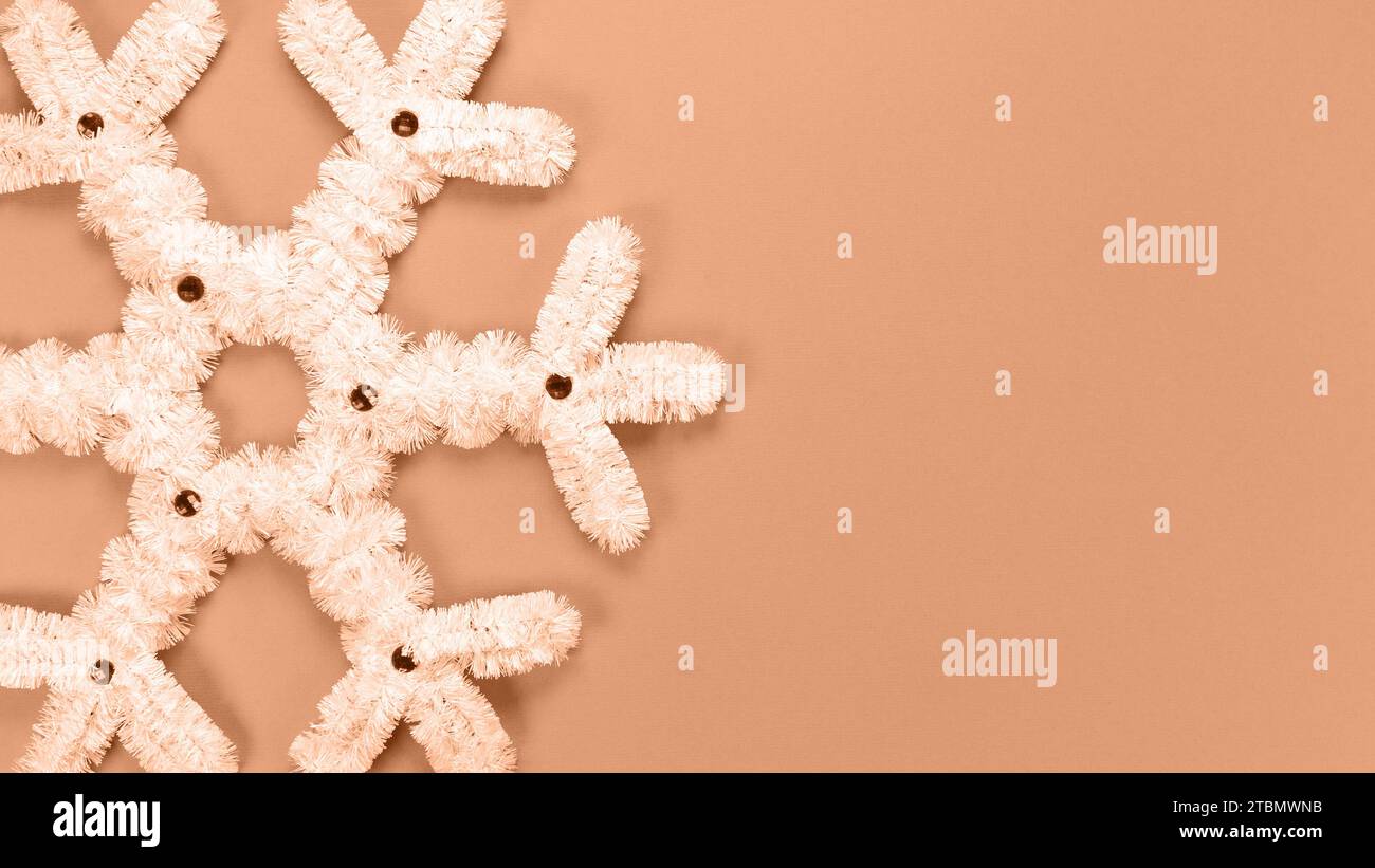 Fluffy white snowflake Christmas decor. Image toned in Peach Fuzz color ...
