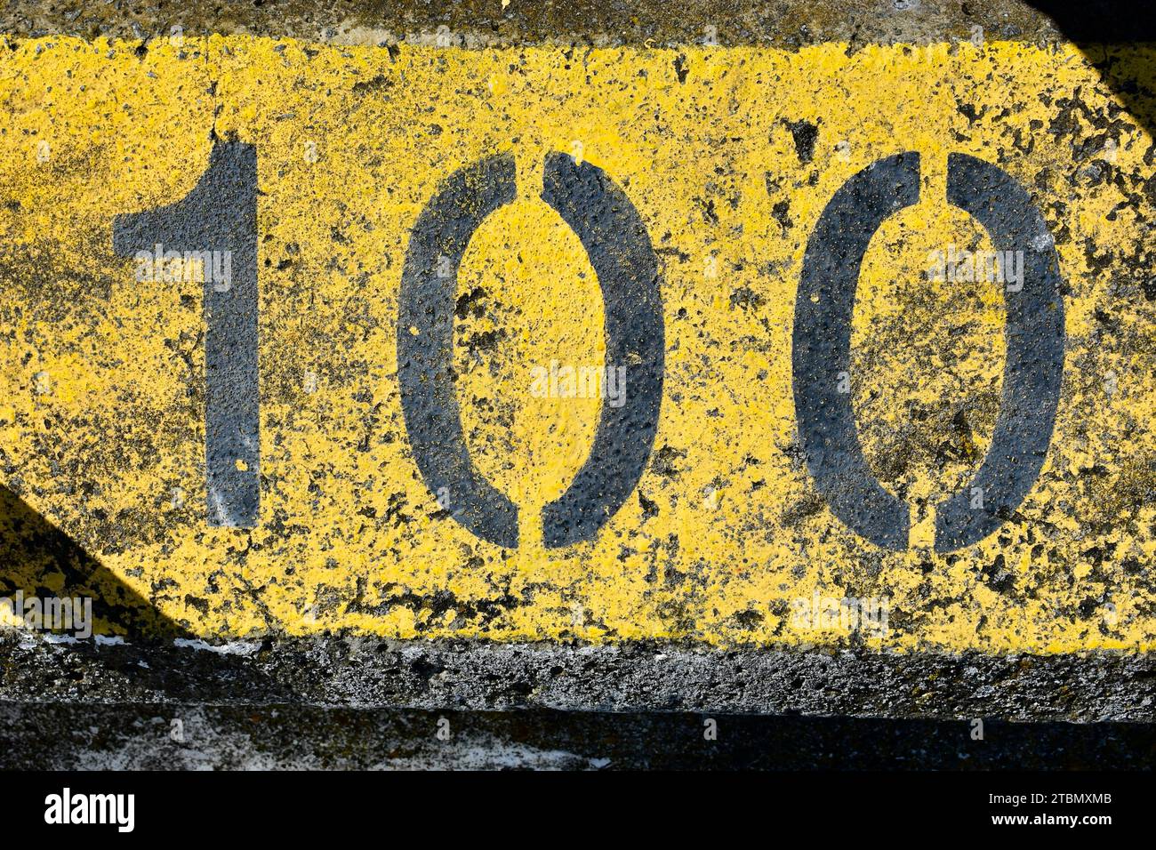 The number 100, one hundred, one; painted in black and yellow; an ...