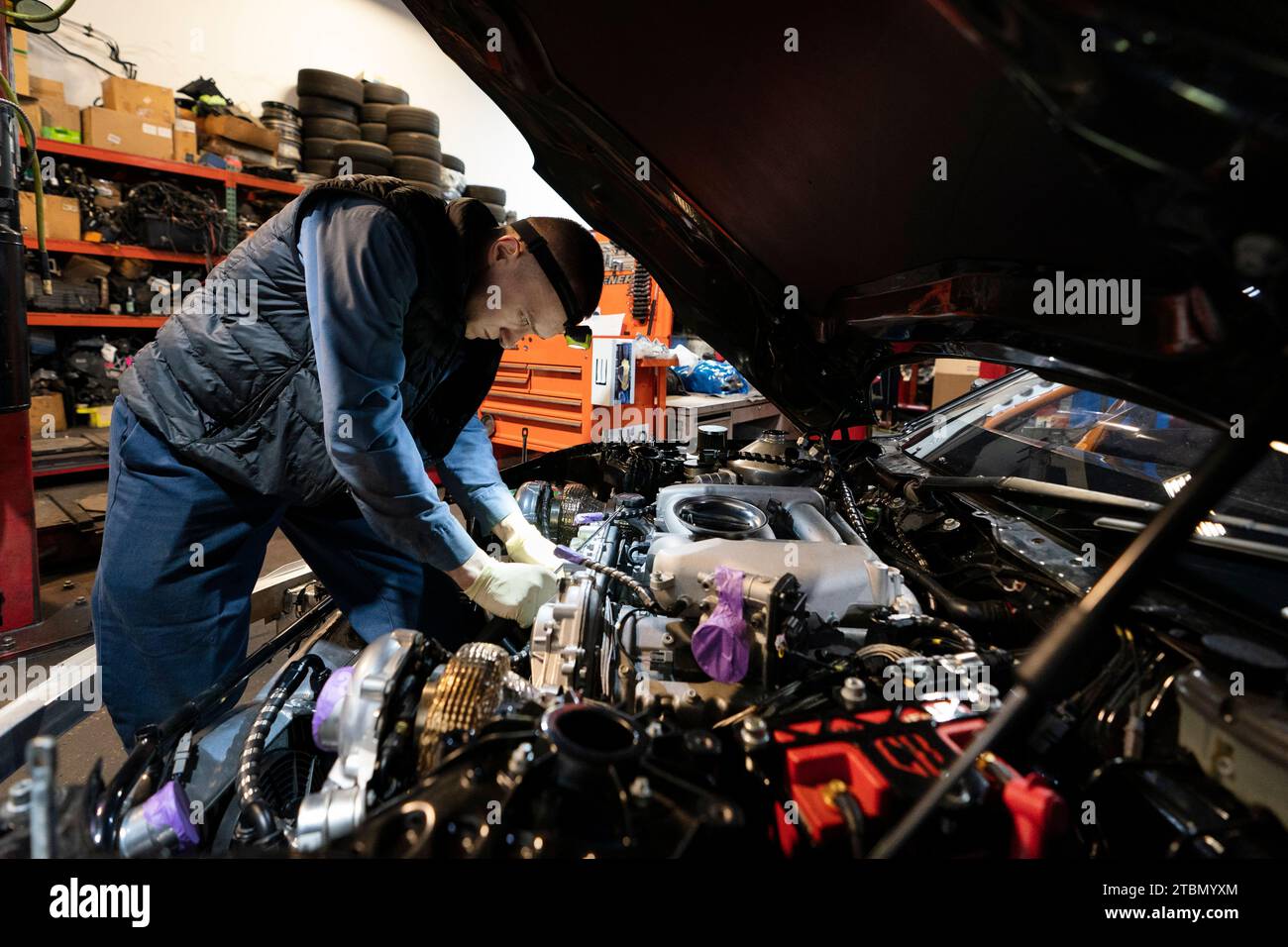 File - Mechanic David Stoliaruk works on the engine of a car at IC Auto ...