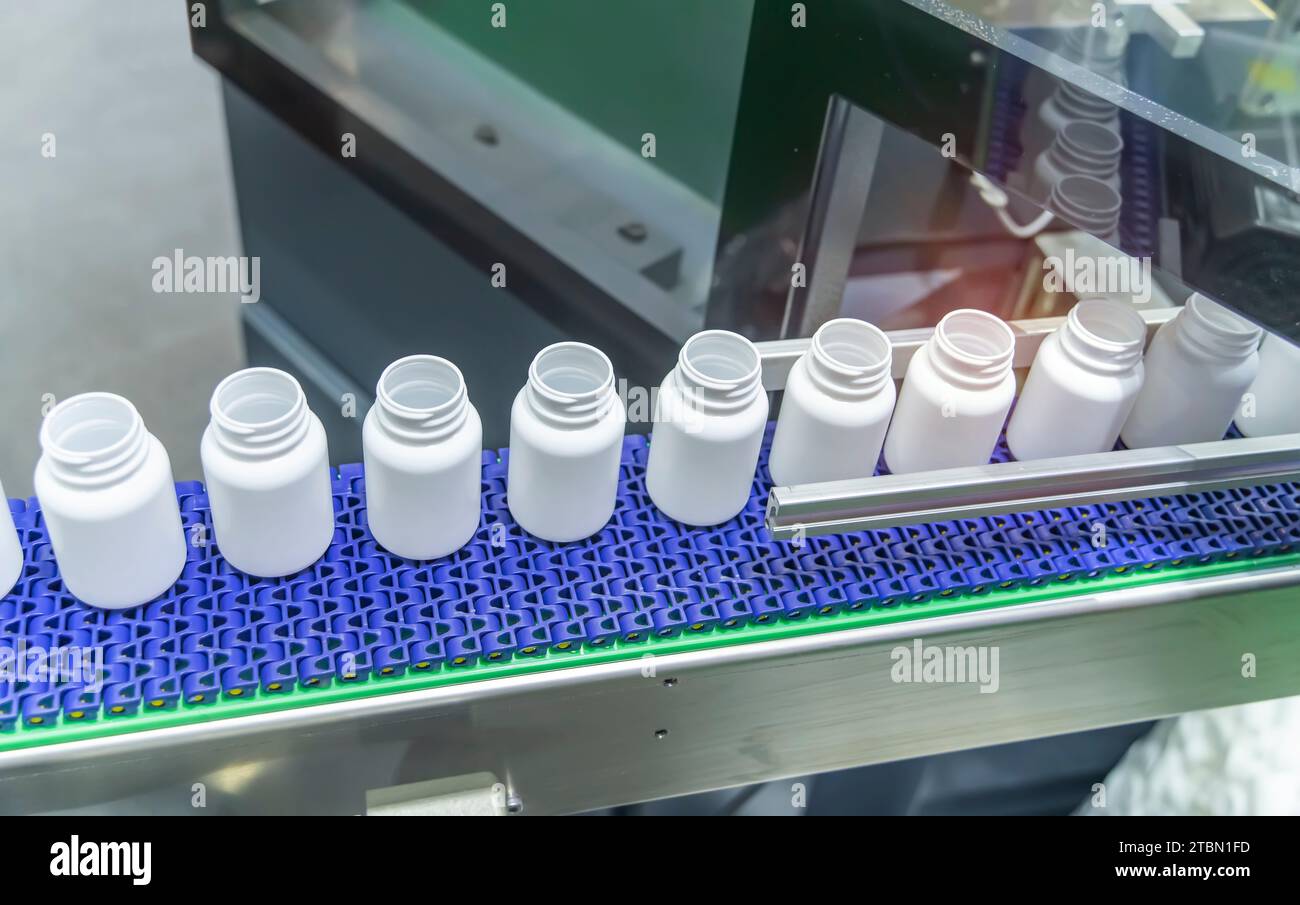 Moving polypropylene white bottles on conveyor belt of automatic liquid ...