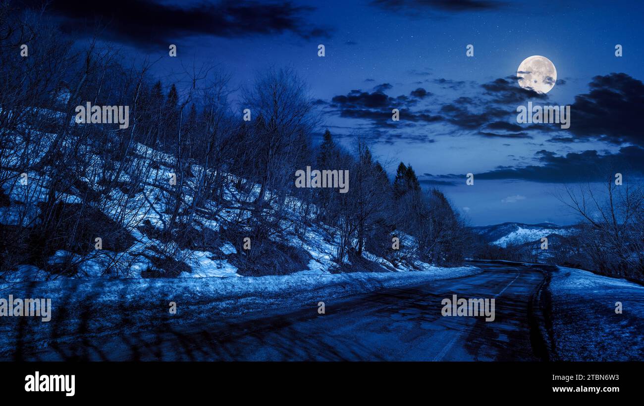 pass with snow on the roadside at night. mountainous winter landscape ...