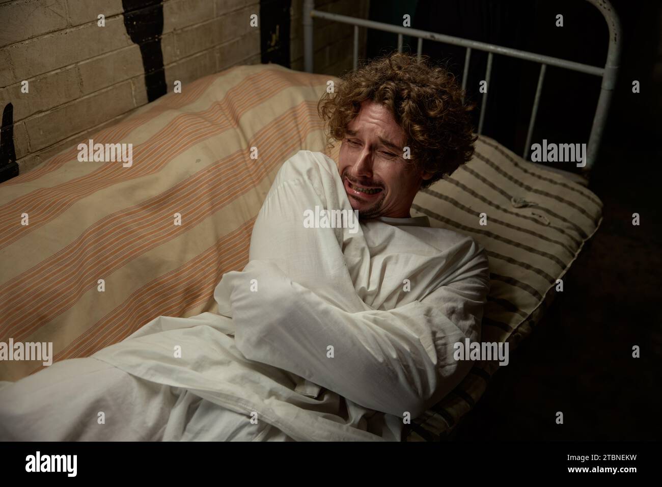 Crazy psycho man wearing straitjacket crying and screaming lying in ...