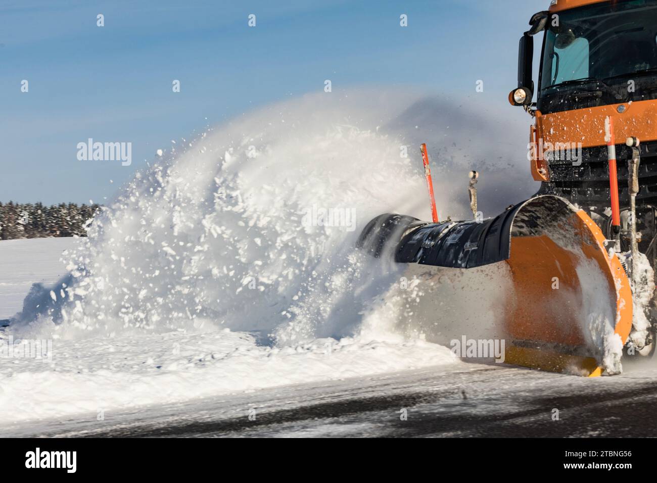 A close-up view of the snowblower's blade throwing snow off the runway ...