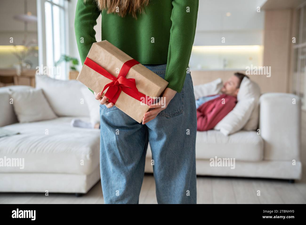 Gift box with ribbon for holiday. Woman holding present behind back ...