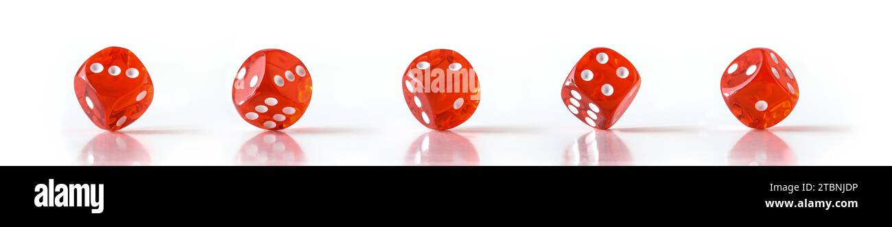 Set of red gambling dice resting in a corner on reflective white table ...