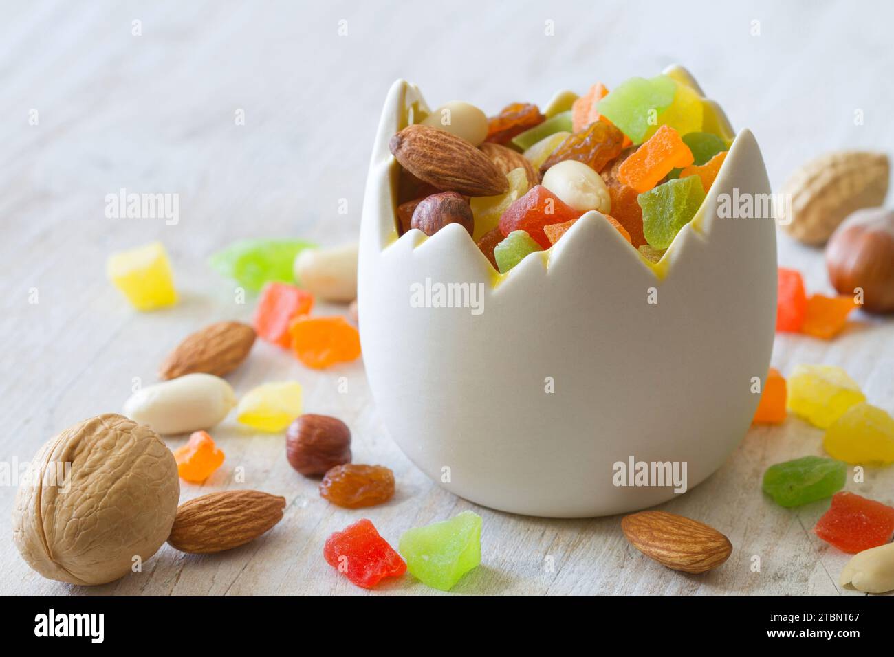 Mix of nuts and candied fruits in eggshell shaped bowl on light ...