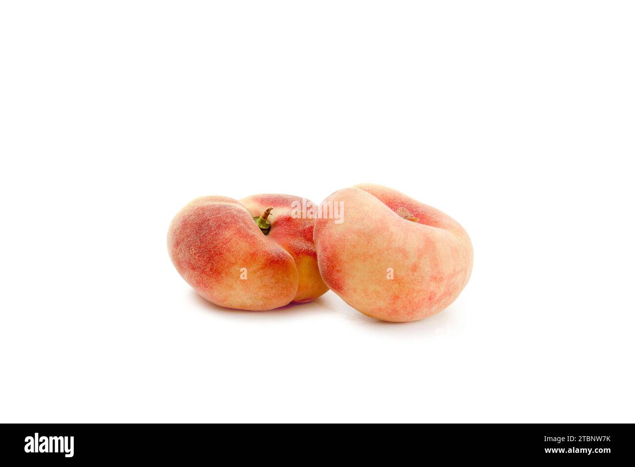 Two ripe chinese flat peach fruits or saturn peaches with soft shadow ...
