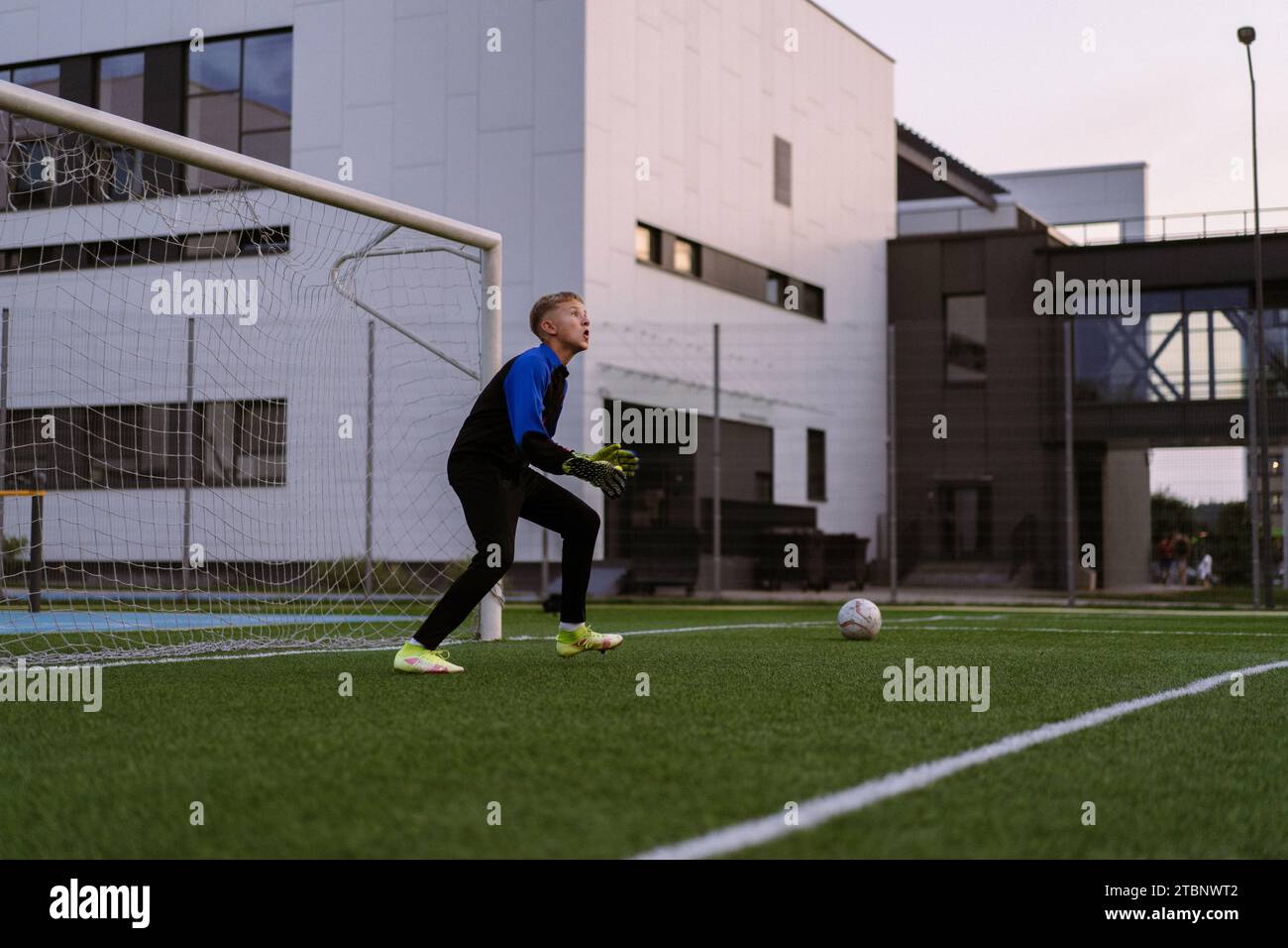Kids playing soccer, boy goalkeeper catches ball in goal Stock Photo ...