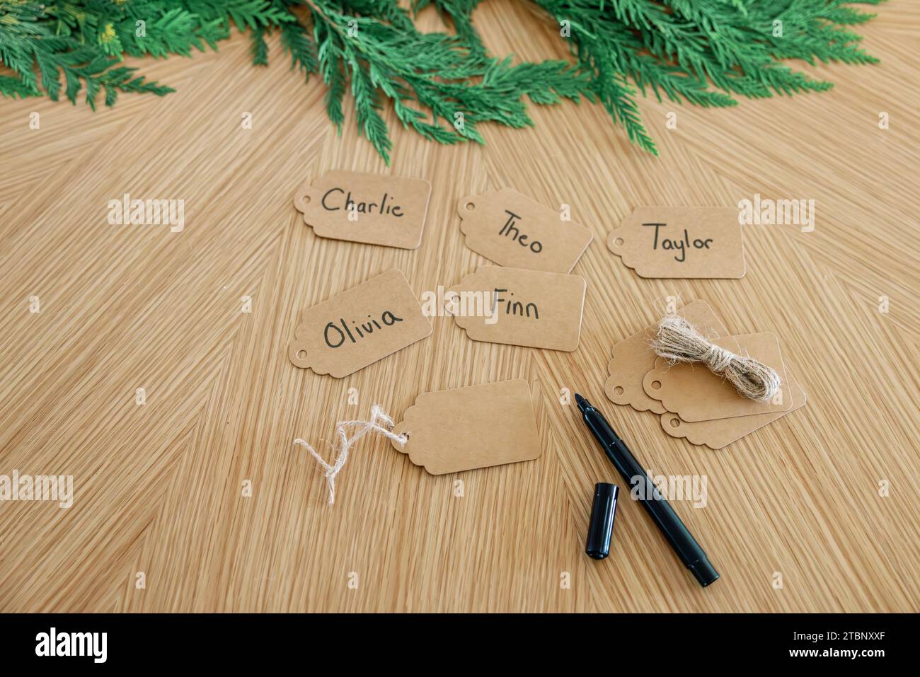 Festive handwritten gift tags on wood with greenery Stock Photo - Alamy
