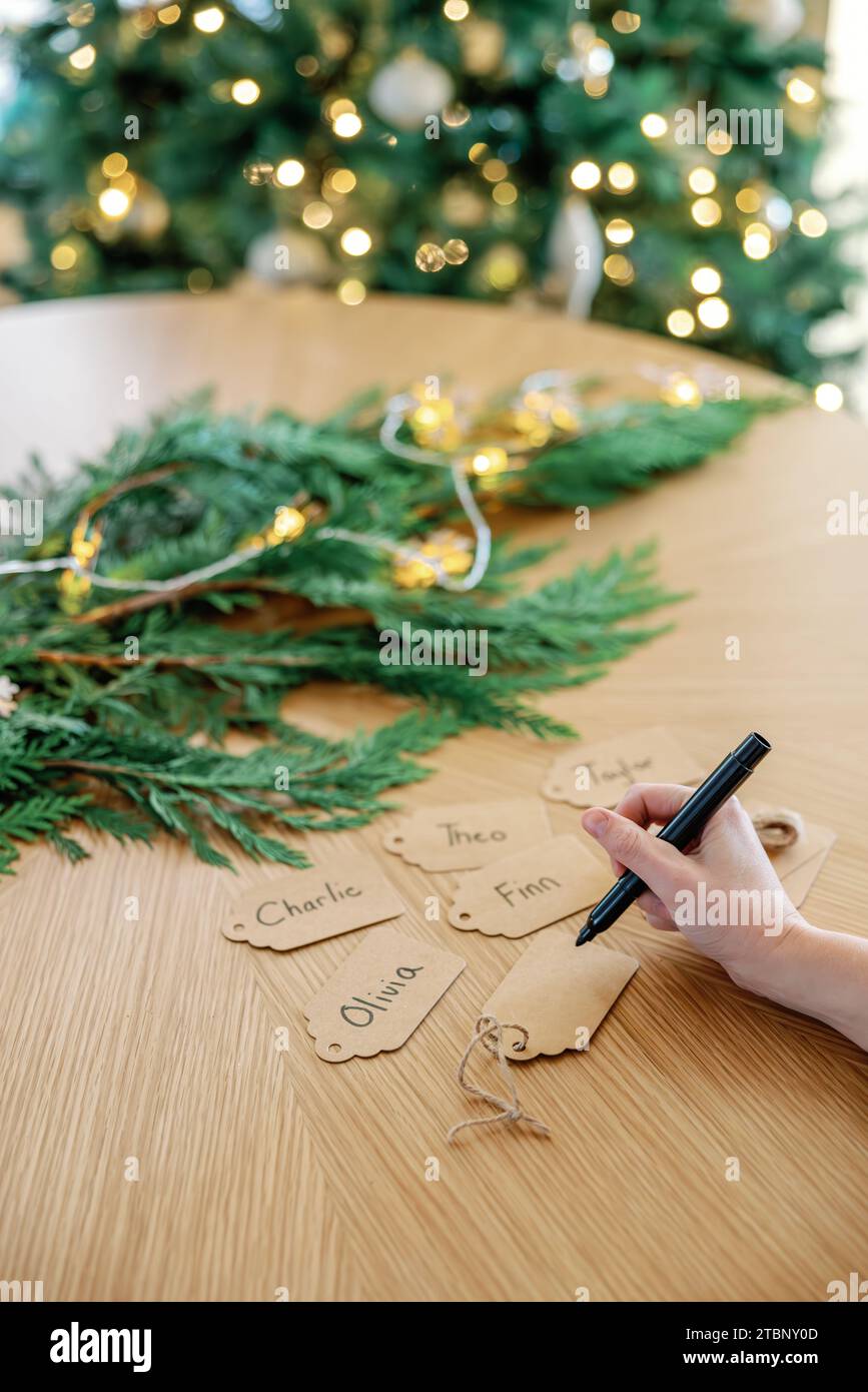 Personalizing gift tags with Christmas tree backdrop Stock Photo - Alamy