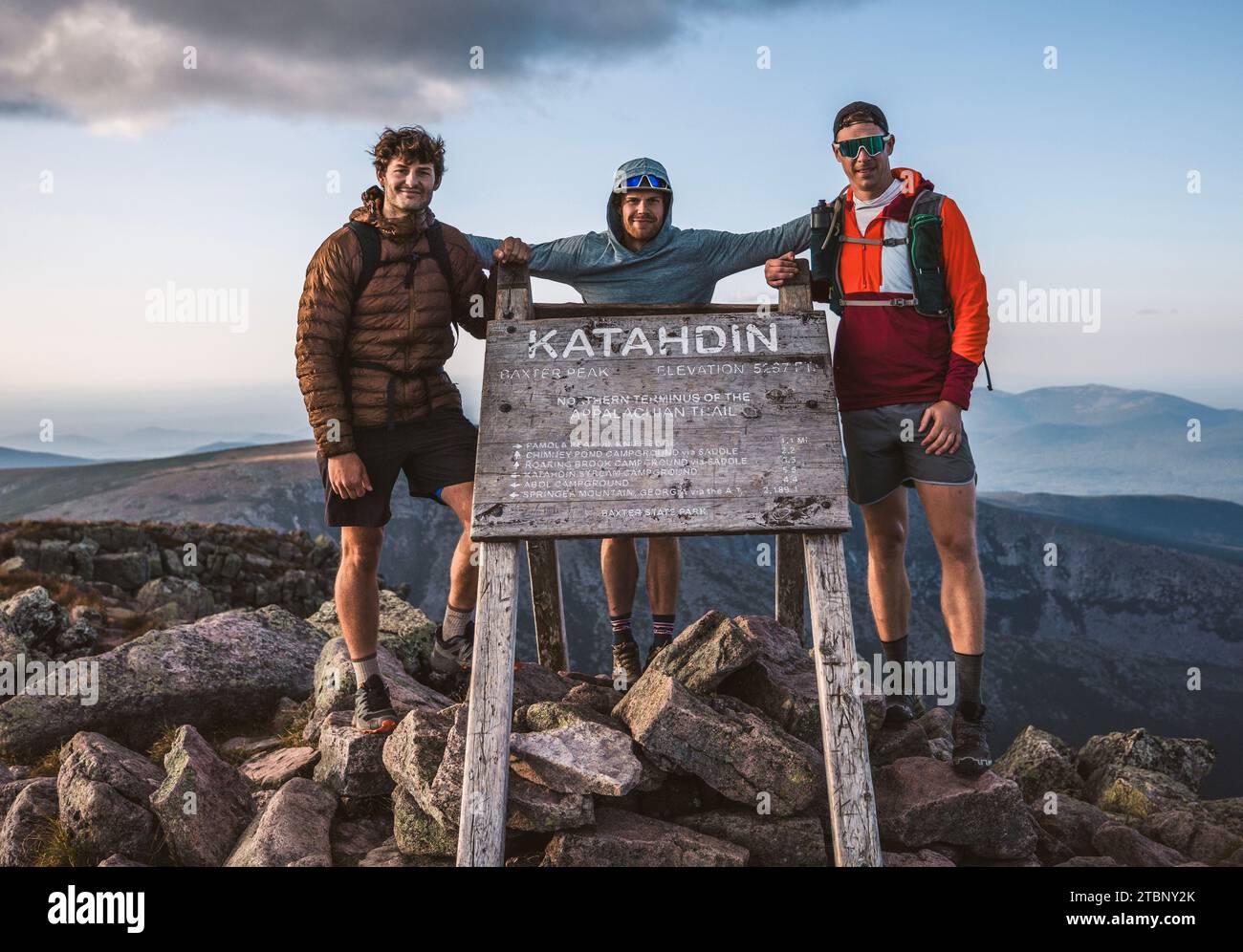 Three male friends stand at summit sign of Katahdin, Appalachian Trail ...