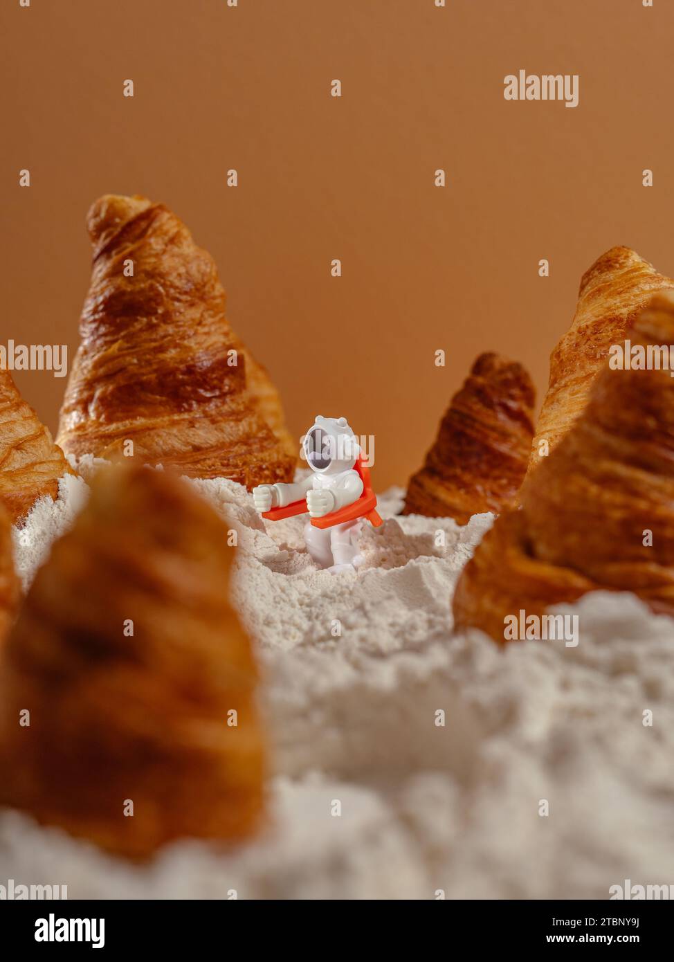 Toy world. astronaut walking among the mountains of croissants Stock ...