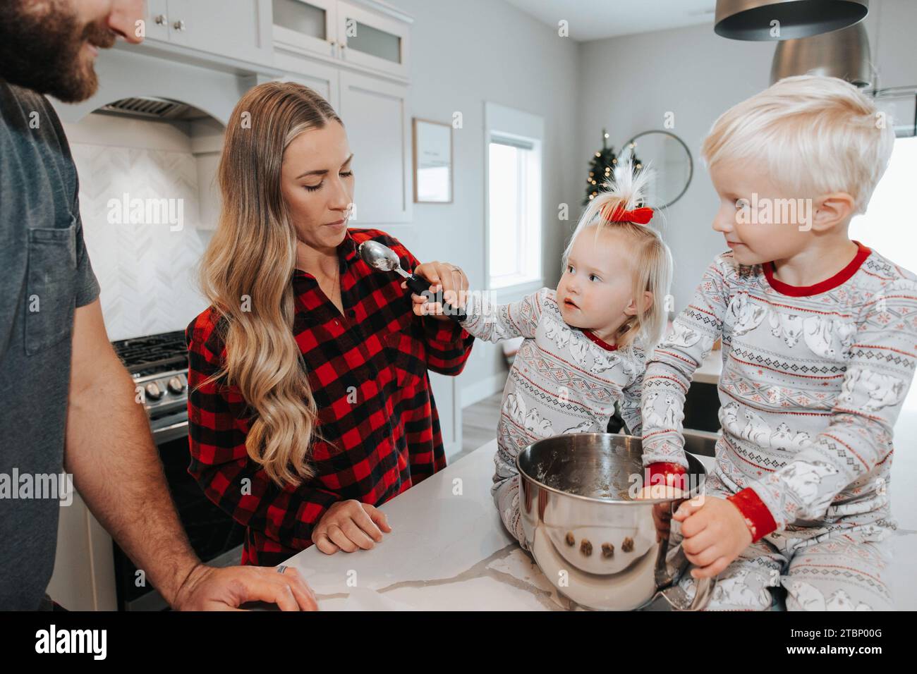 Girl feeds mom dough in family chocolate chip bake Stock Photo - Alamy