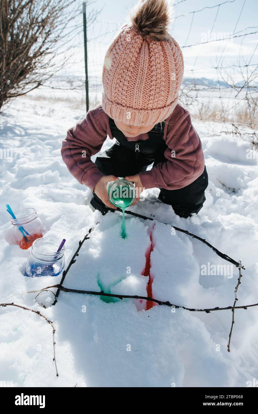 Girl paints snow with sticks Stock Photo - Alamy