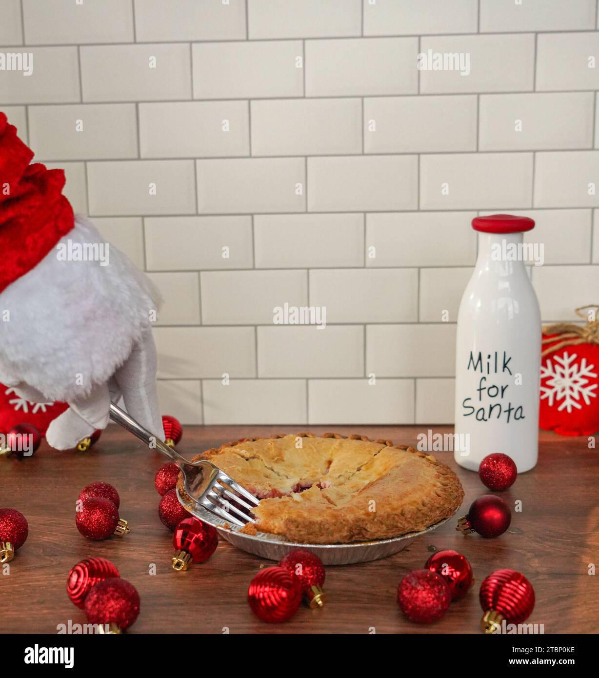 Santa getting a bite of cherry pie in the kitchen Stock Photo - Alamy