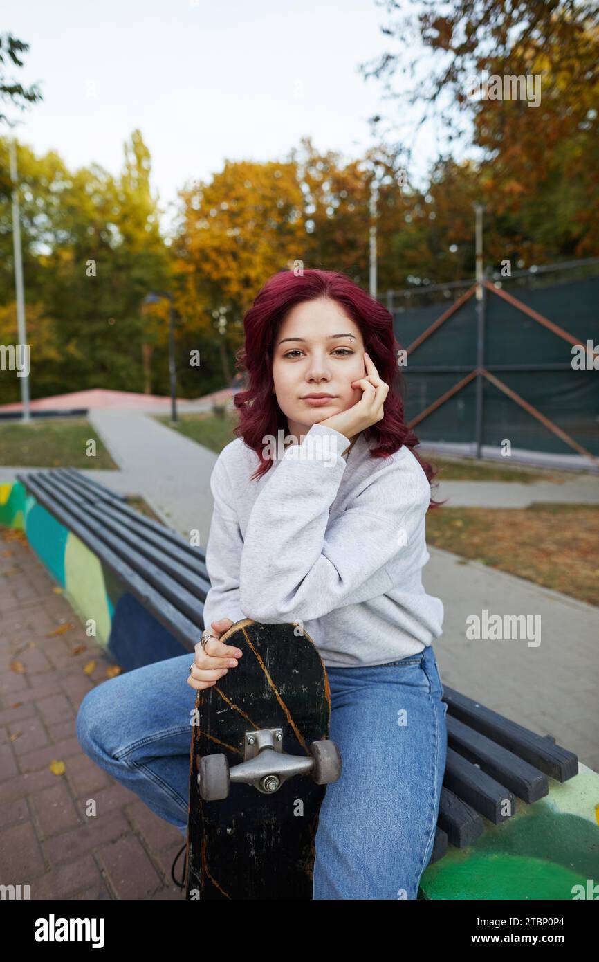 girl sitting on bench looking at camera outdoors Stock Photo - Alamy