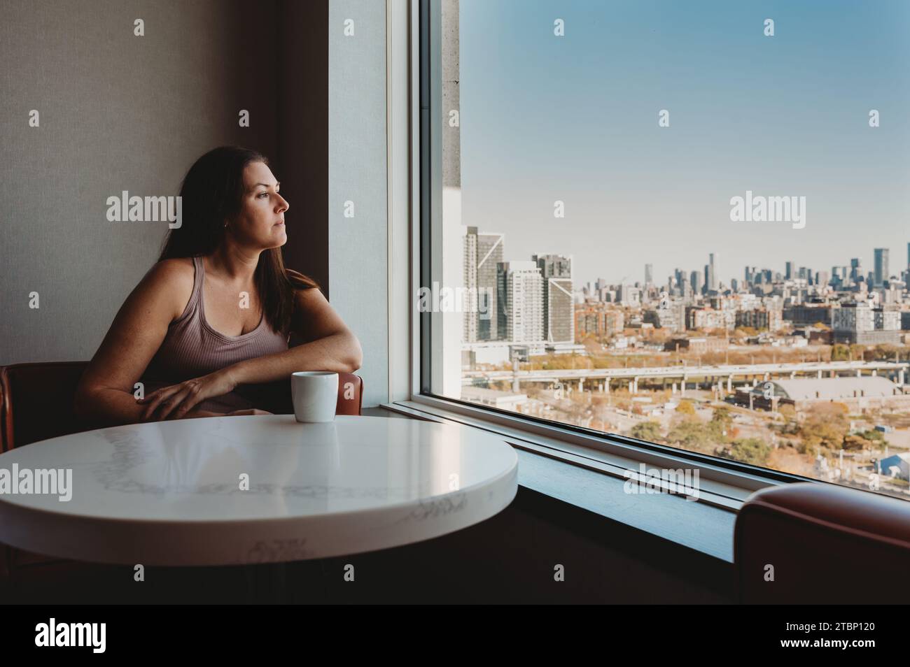 Woman sitting alone at table hi-res stock photography and images - Alamy