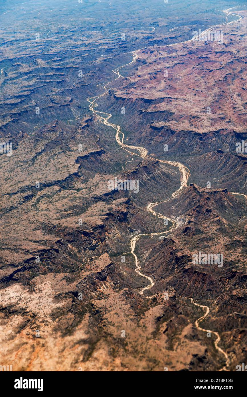 Arid landscape with dry creek and winding track along the coast of ...