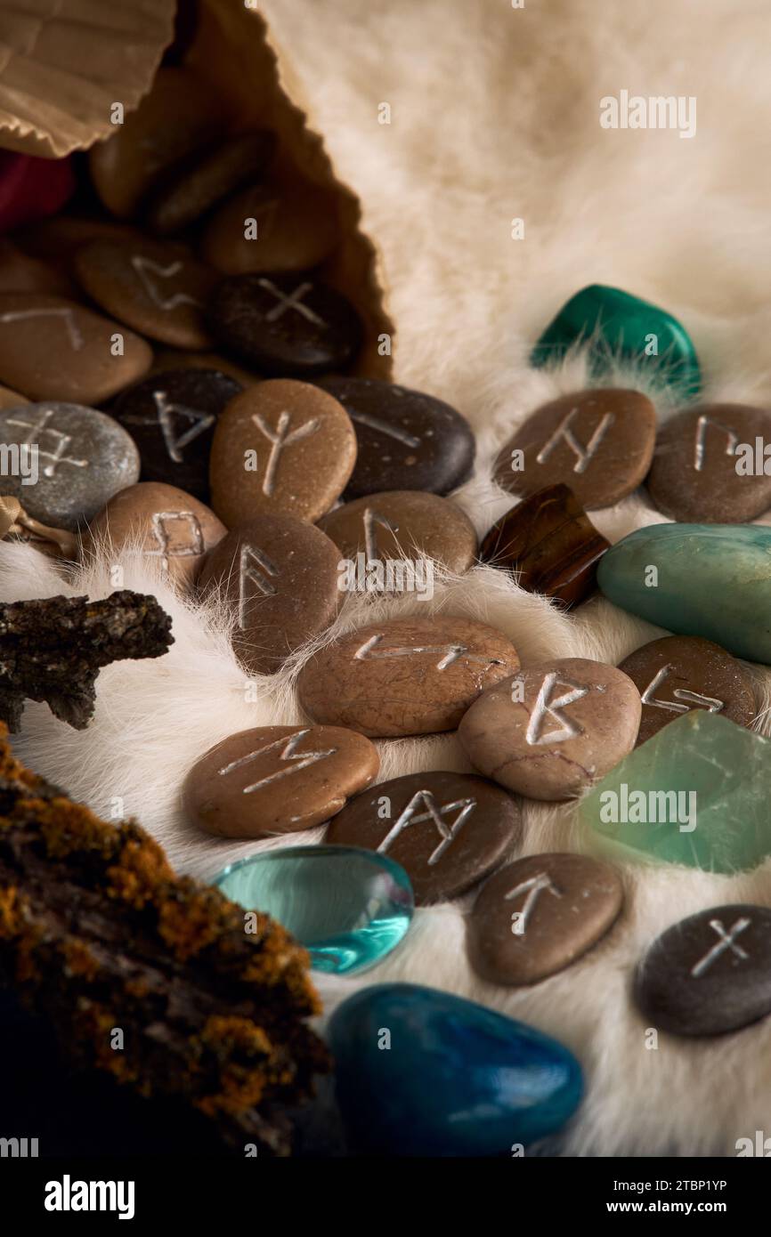 handmade stone runes, crystal ball and gems on white fur for predicting ...