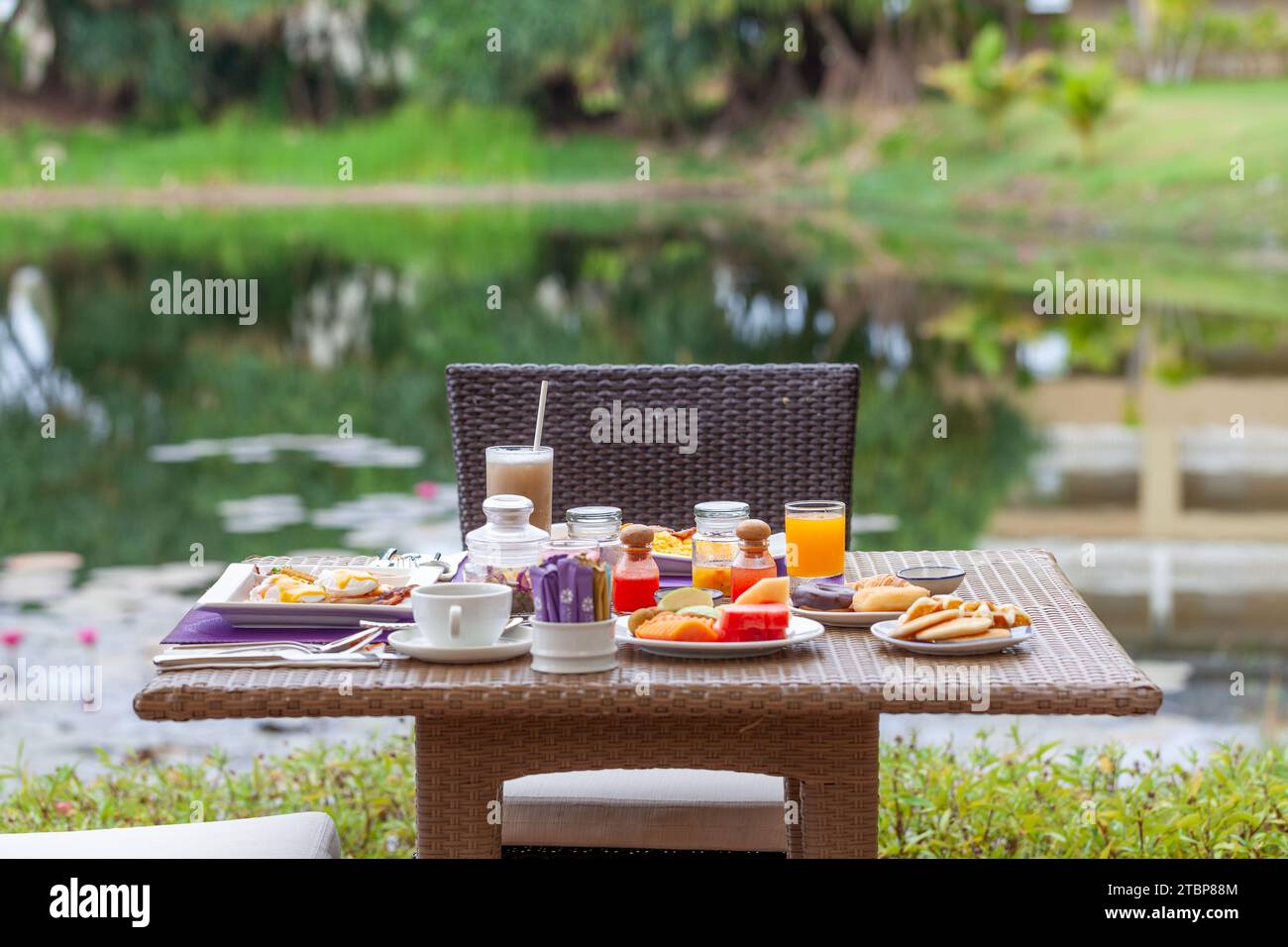 Outdoor breakfast setup at luxury resort with tropical garden view ...