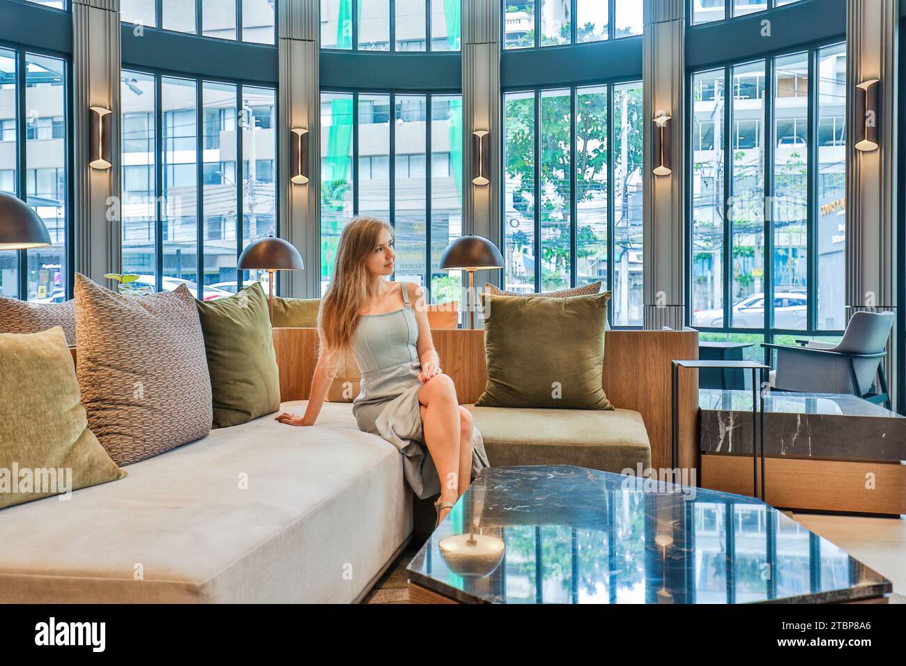 Woman relaxing in modern lounge area with elegant interior design ...