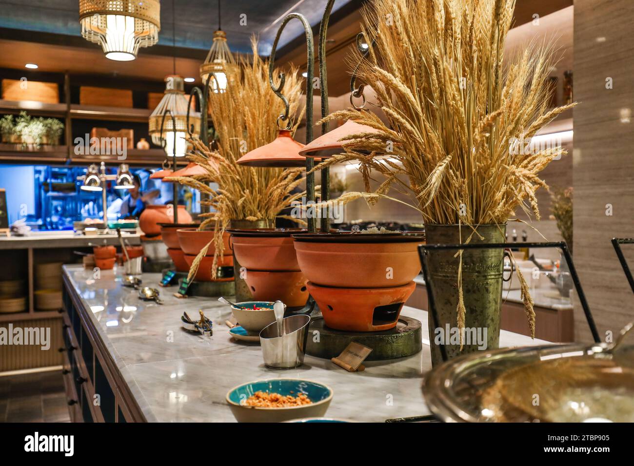 Rustic buffet setup with earthenware pots and wheat decoration ...