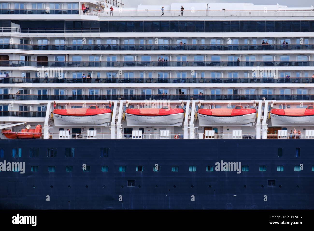 View of side of a large cruise ship with balcony, lifeboats and some ...