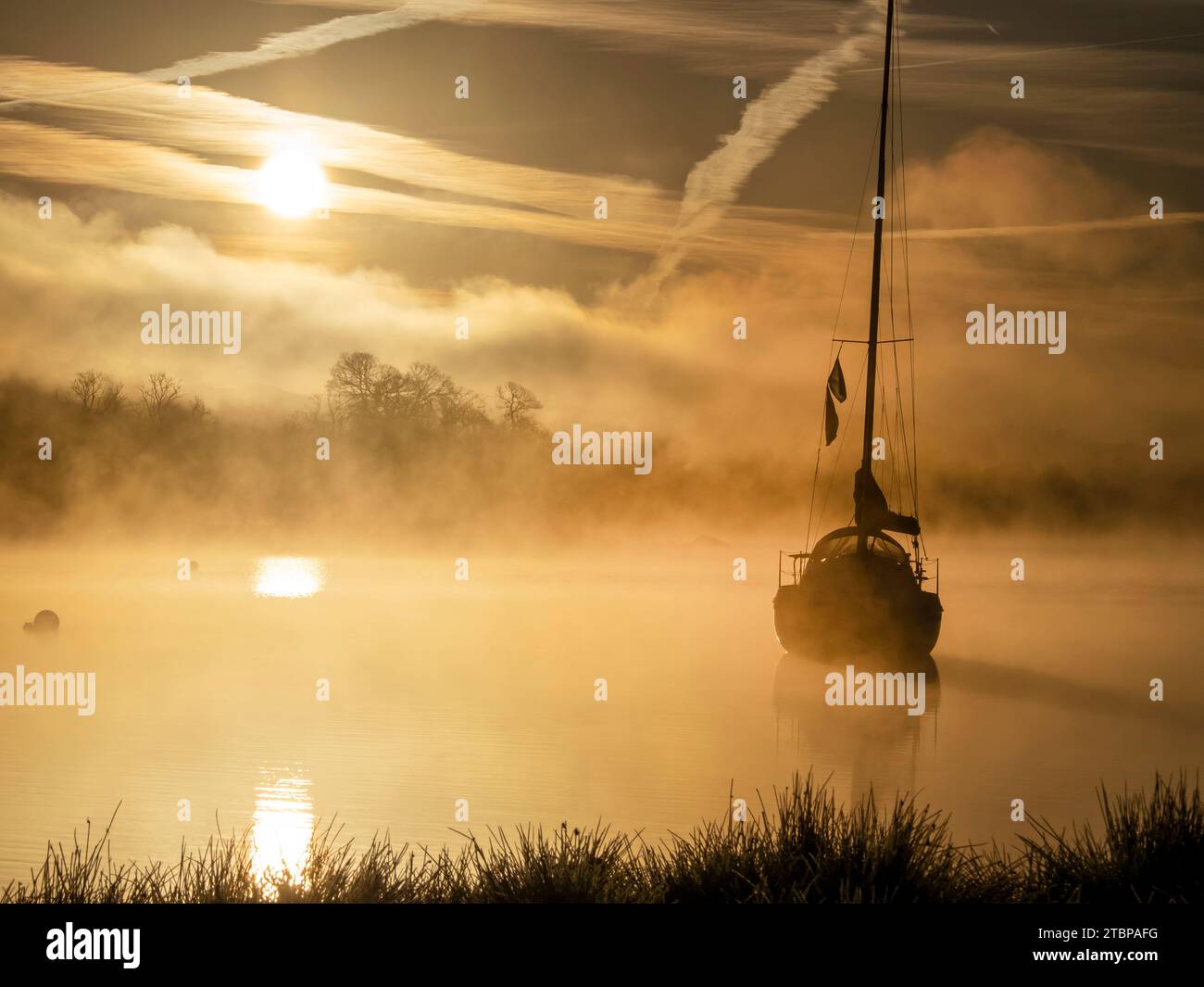 Yachts on Lake Windermere at dawn, with morning mist over the lake ...