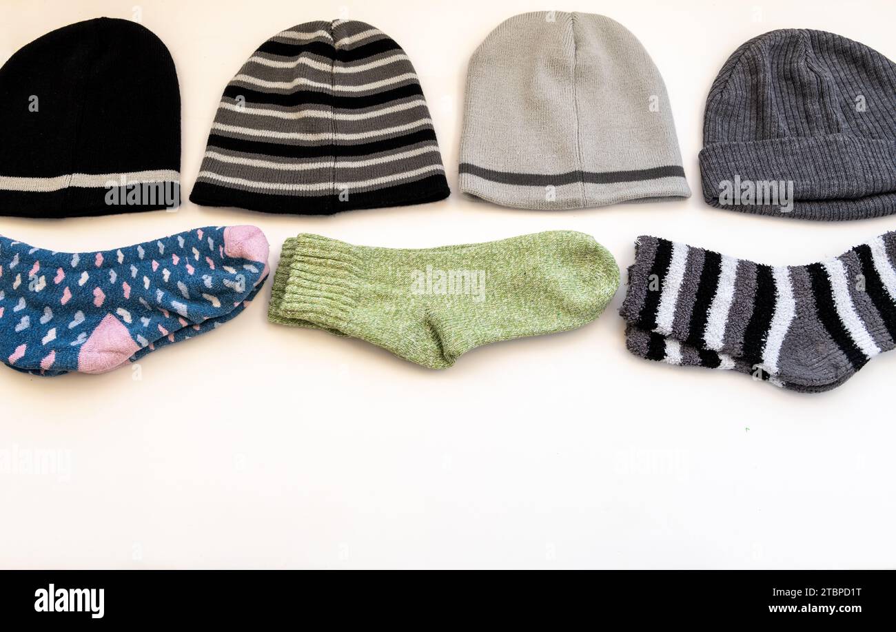Different pattern woolly hats and thick Winter socks isolated in a ...