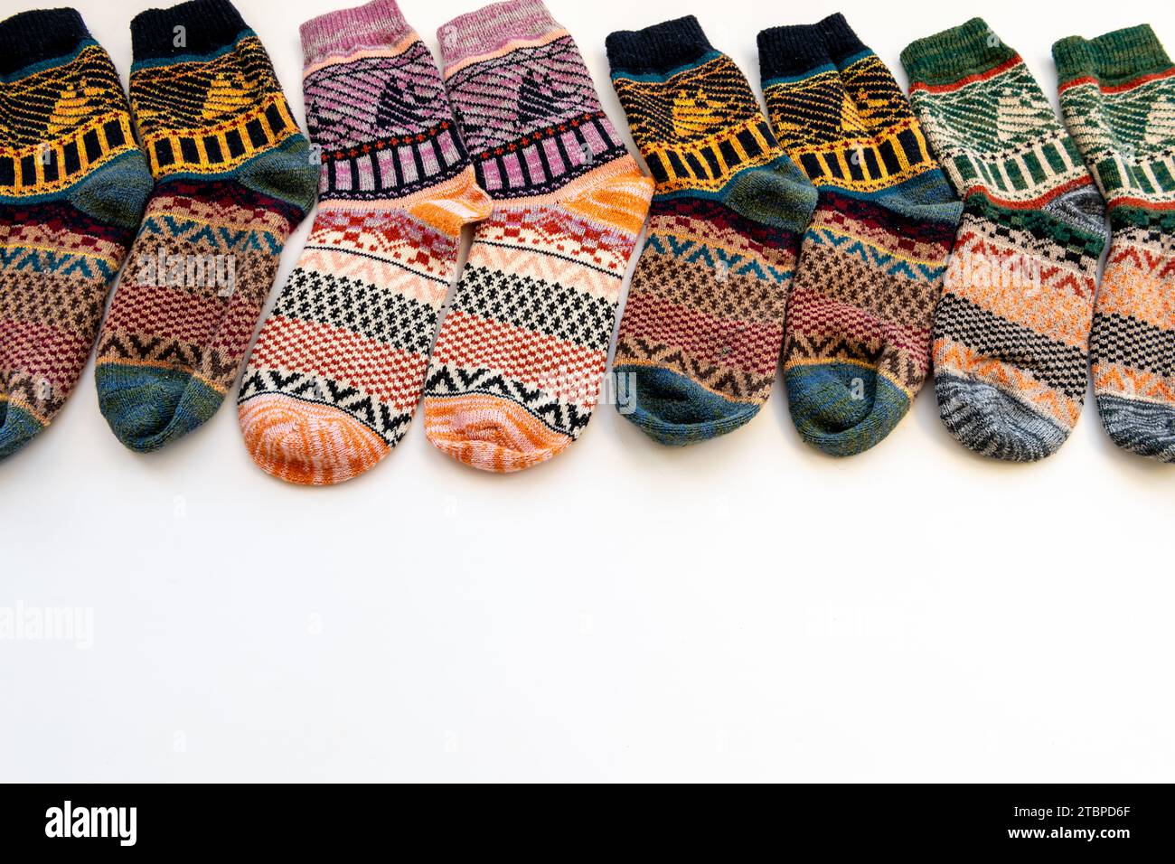 A row of colourful Winter woollen socks of various patterns isolated in ...