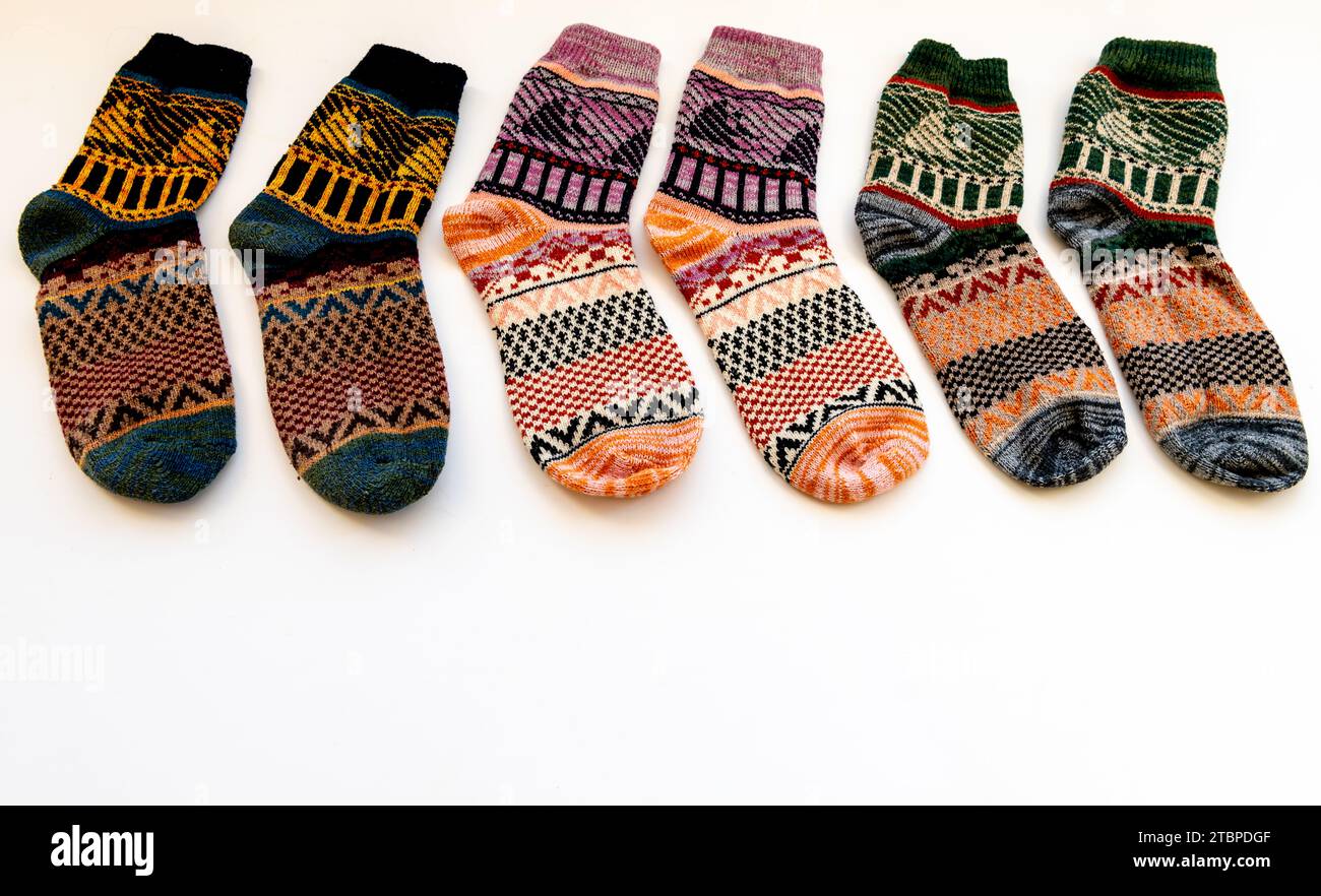 A row of colourful Winter woollen socks of various patterns isolated in ...
