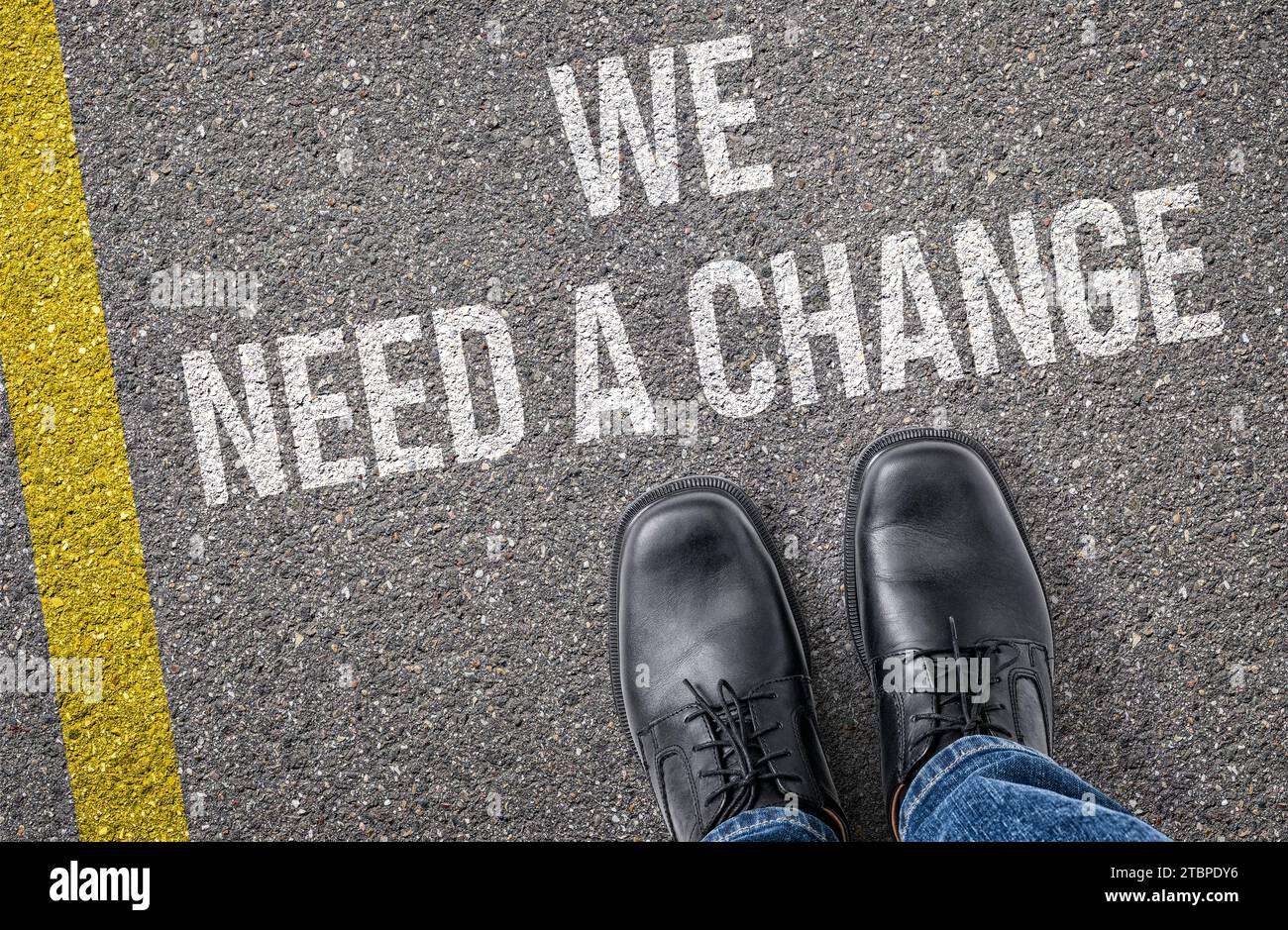 Text on the road - We need a change Stock Photo - Alamy