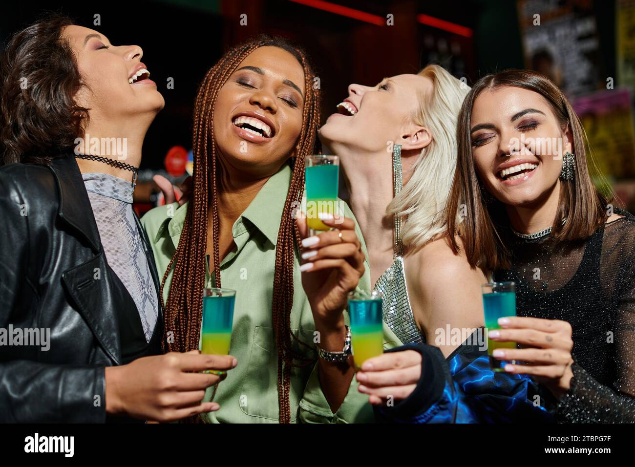 happy multicultural girlfriends with shot glasses smiling with closed ...